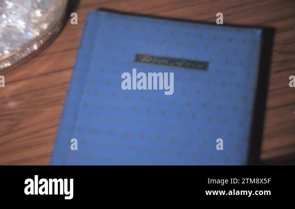 Zoom on a blue photo album with golden patterns on the cover on brown ...