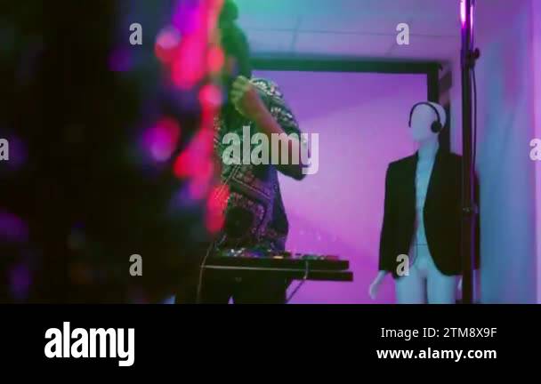 Young man mixing sounds on stage at party, having fun partying with ...