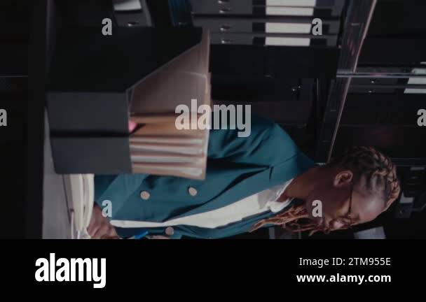 Vertical video: African american agents reading statements reports in ...