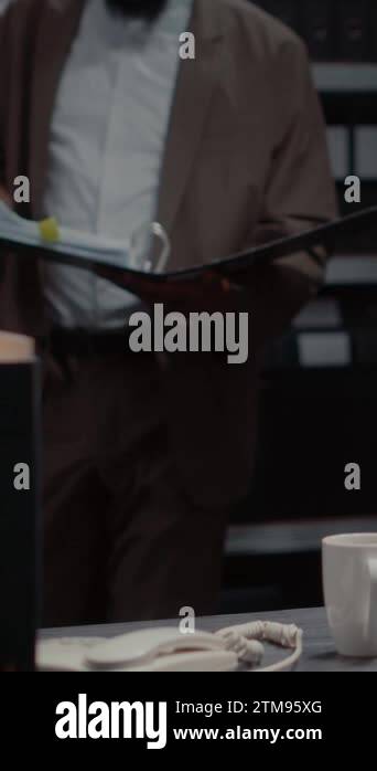 Vertical video: Investigator studying folder with police archive ...