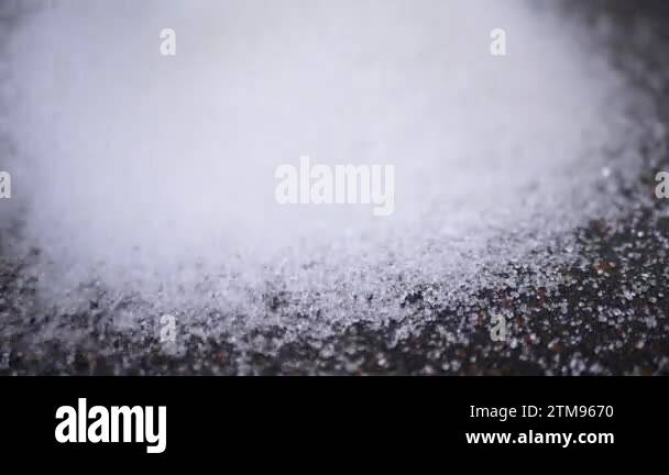 White Crystals of Granulated Sugar Fall on a Black Background in Slow ...