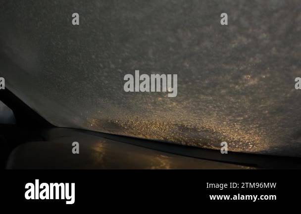 The process of melting snow on the windshield of a car at night. Melted ...