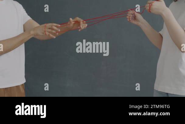 Man and woman moving hands tied with red rope expressing complicated ...