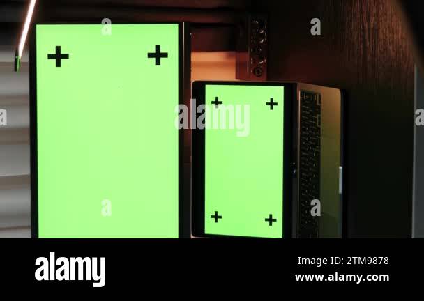 Big computer and laptop screens with green chroma key. Vertical video ...
