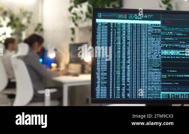 Monitor of computer in modern IT company office with big database code ...