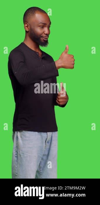 Vertical video: Side view of casual person giving thumbs up on camera ...