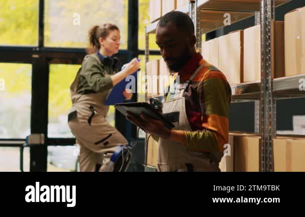 African american man using scanner in warehouse to scan barcodes on ...