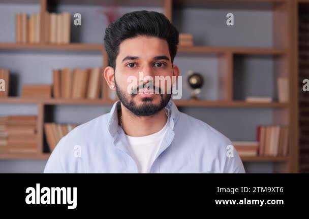 Serious looking Latin Spanish man is posing for a portrait in an office ...