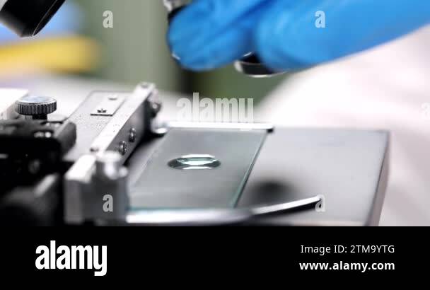The lenses of the microscope lens above a drop of liquid, close-up ...
