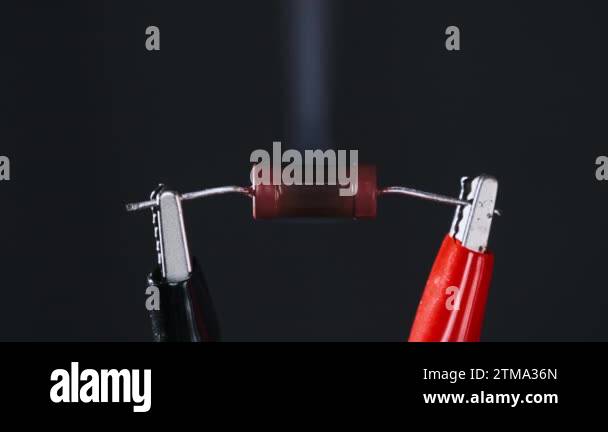 The resistor heats up with smoke under a high electric current, short ...