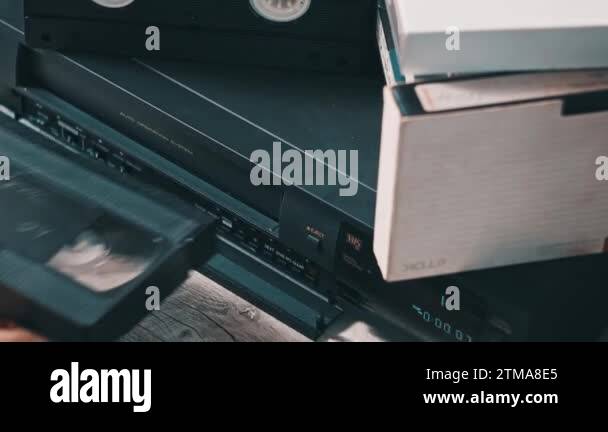 Insert VHS cassette into VCR player. Black vintage videotape cassette ...