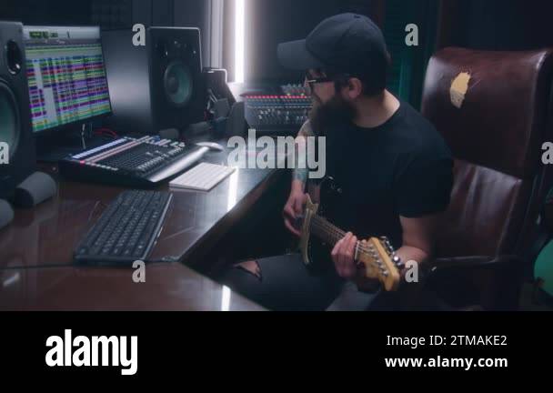 Sound engineer, musician plays electric guitar, records melody for ...