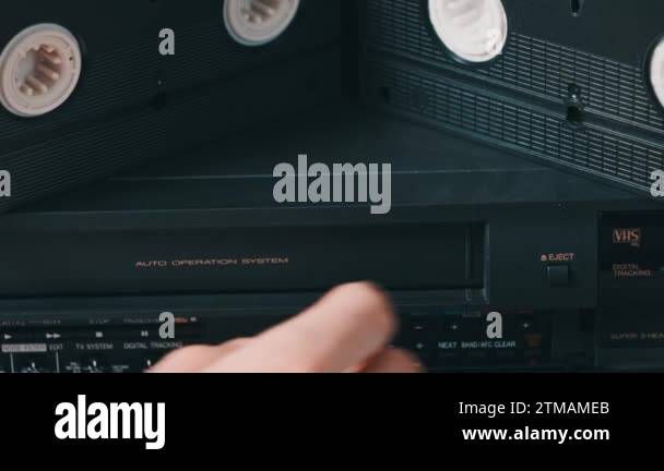 Eject VHS tape cassette from VCR player. Male hand pushes a button and ...