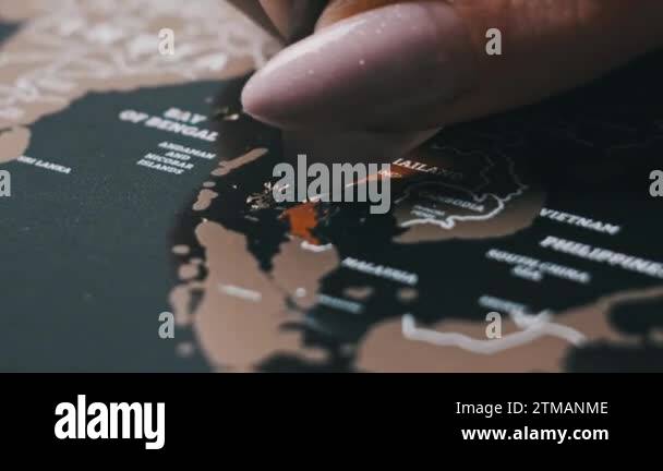 Woman hand erases visited country of Thailand on the travel map ...