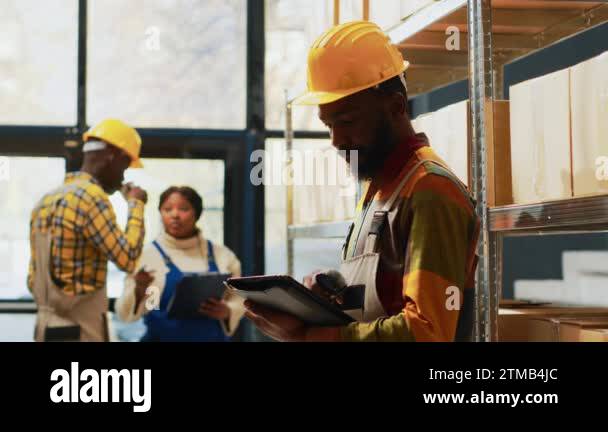 Depot worker scanning barcodes on stock boxes, using scanner and ...