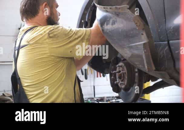 Professional auto mechanic disassembling car before repair. Repairman ...
