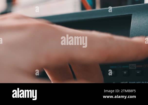 Eject VHS tape cassette from VCR player. Male hand pushes a button and ...