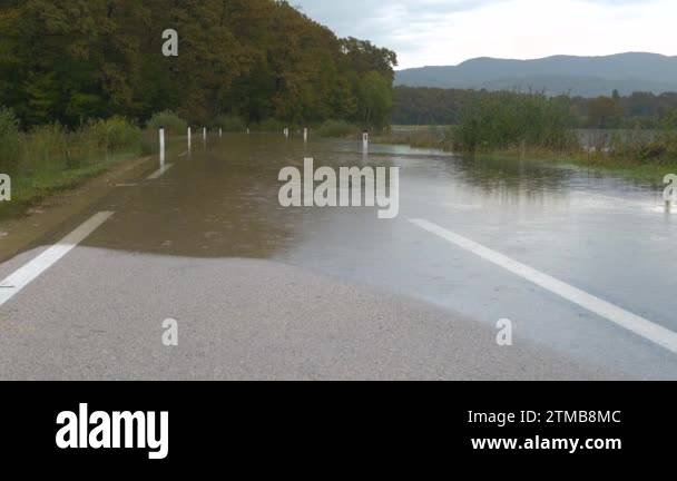 River overflowed its banks and flooded a part of asphalt road in the ...