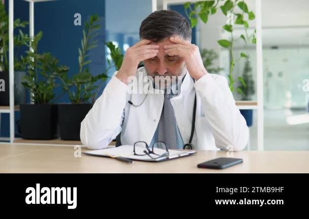 Stressed frustrated senior doctor wearing white uniform with ...
