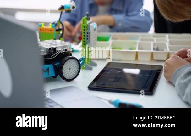 Robotics programming class. Children construct and code Robot. STEM education using constructor ...