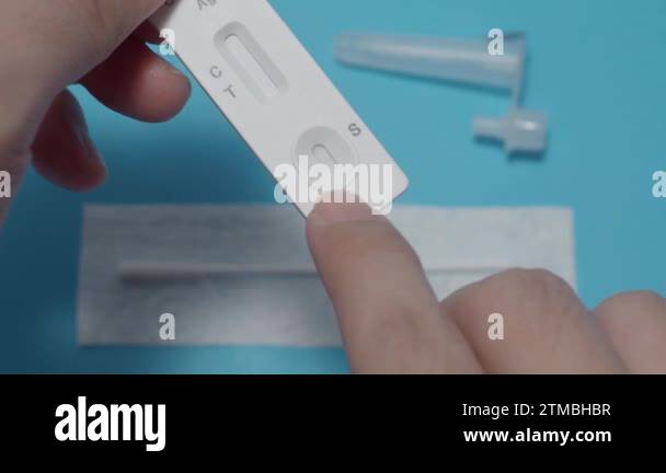 POV of Man hands using Rapid antigen test kit or ATK and blue ...