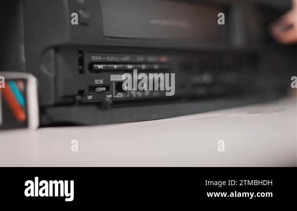 Eject VHS tape cassette from VCR player. Female hand pulls out VHS from ...