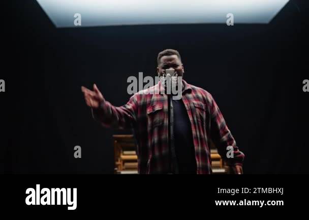 A passionate singer waves and makes hand gestures while performing a ...