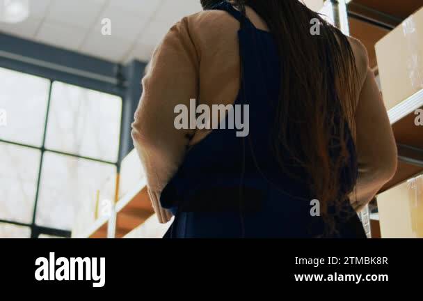 African american girl analyzing boxes on depot racks in warehouse ...
