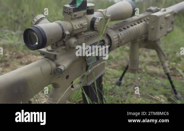 camouflage sniper rifle is on the ground in the grass. airsoft guns ...