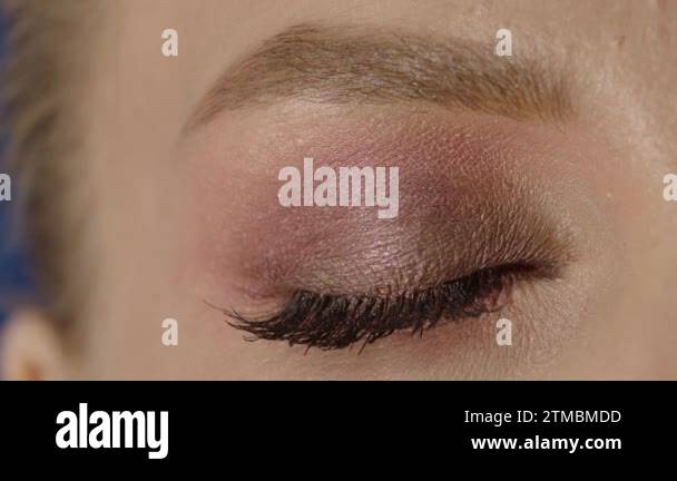 Close-up shot of opening female eye with makeup. The reaction of the ...