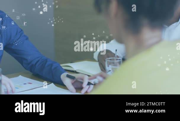 Animation of multiple icons over diverse coworkers discussing reports ...