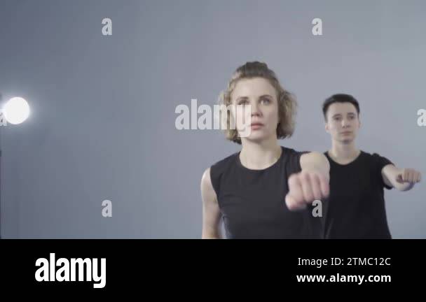 Two athletic women practicing hand blows in taekwondo in synchronized ...