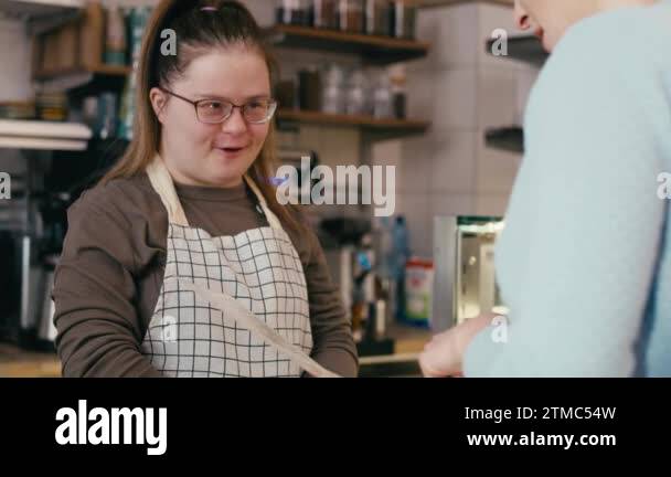 Down syndrome girl advising client what to choose from the menu. Shot ...