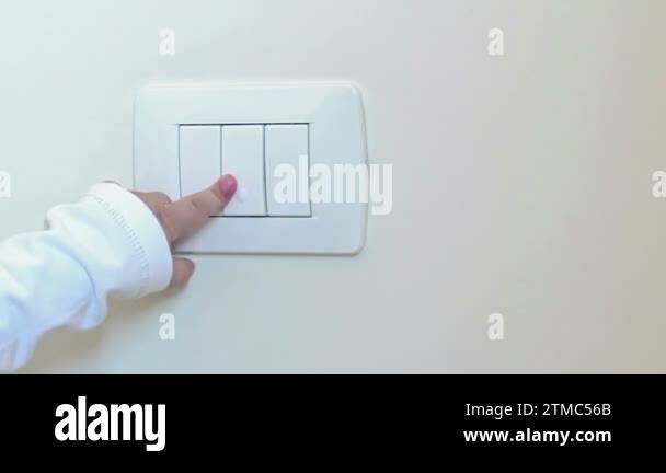 adorable little boy child turning on the white light-switch with his ...