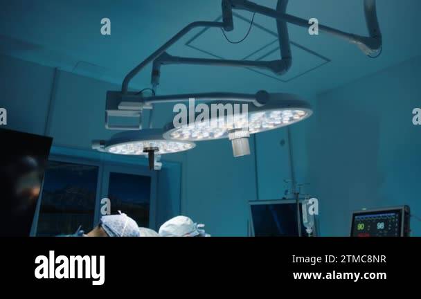 Overview of operating room with three surgeons and patient in process ...