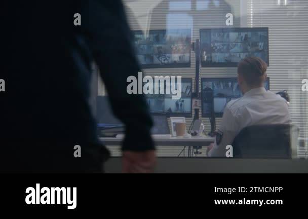 Security guard enters the room to coworker. Security officer controls ...