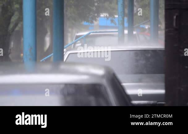 Rain. Rain dripping. Raindrops hit the roof of the car on a street in the city. Rain in the town ...