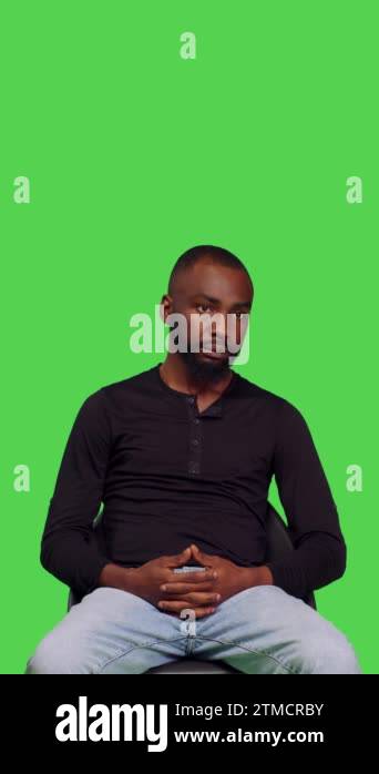 Vertical video: Front view of young adult waiting for something in ...