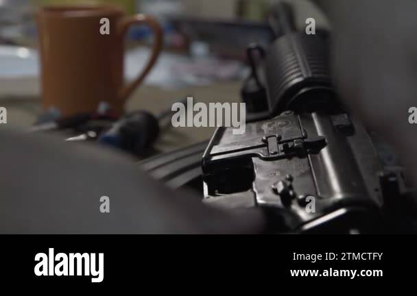 Man repairing a machine gun. Table with tools for repair of weapons ...