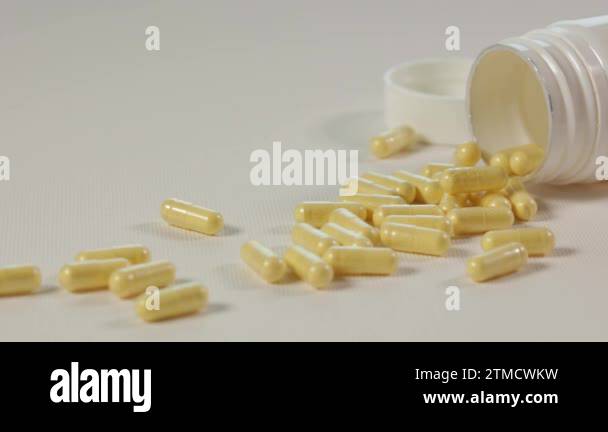 yellow pills spill out of the jar. packaging with medicines close-up ...