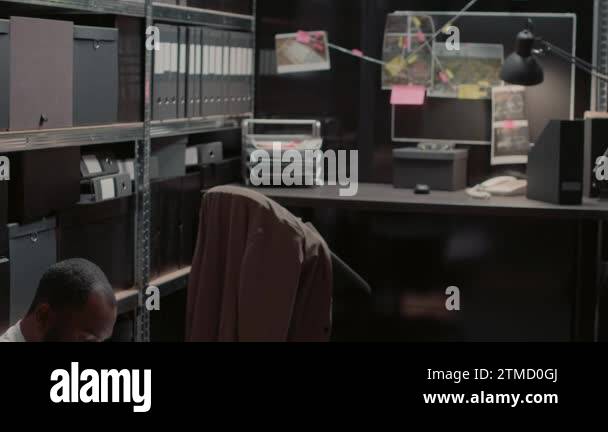 Private detective conducting investigation sitting on floor, being ...