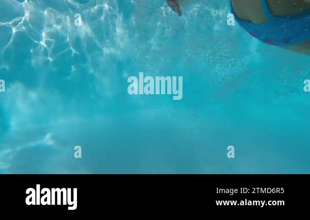 Underwater slow-motion video of a 5-year-old girl swimming, reaching ...
