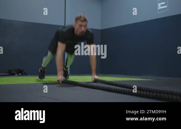 A male athlete performs complex exercises to maintain his health and ...