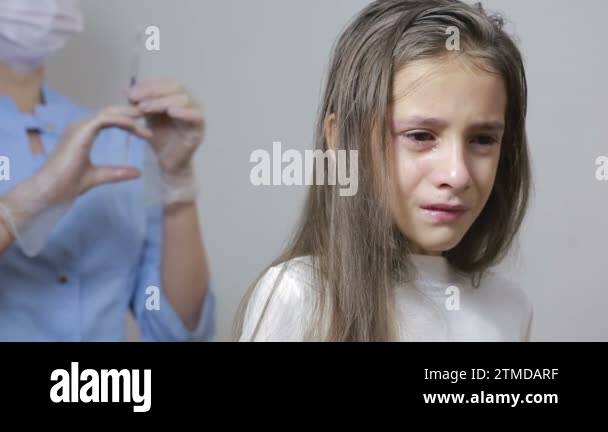 little girl is afraid of the doctor with a syringe. baby cries afraid ...