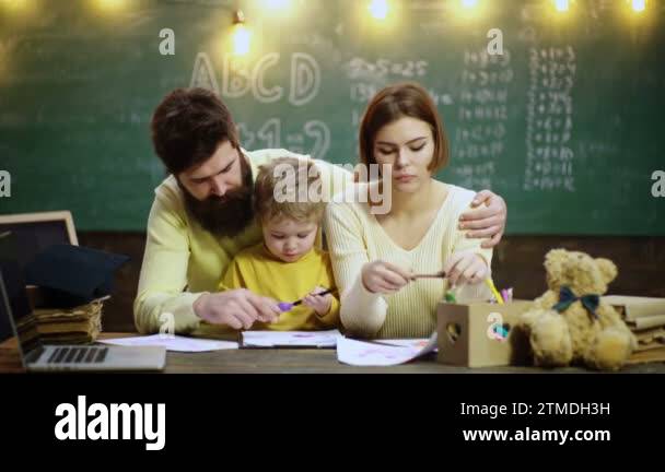 Father and mother teaching children at school. Happy family drawing ...
