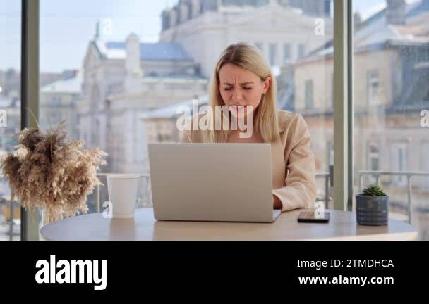 Sick woman is sick standing at workplace, working on a laptop. Girl ...