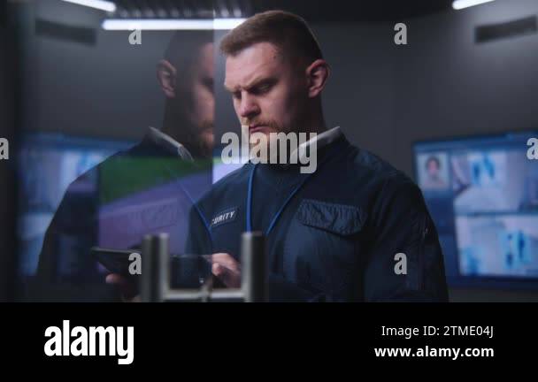 Male security officer controls CCTV cameras in police surveillance ...