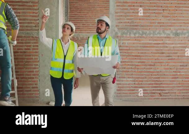 Team architect or engineer man and woman walking and looking blueprint ...