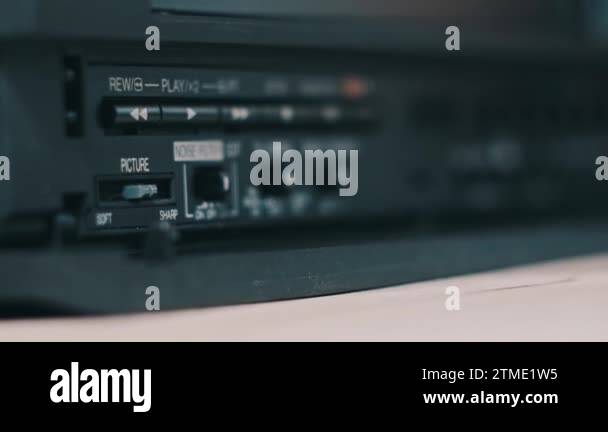 Eject VHS tape cassette from VCR player. Female hand pushes a button ...