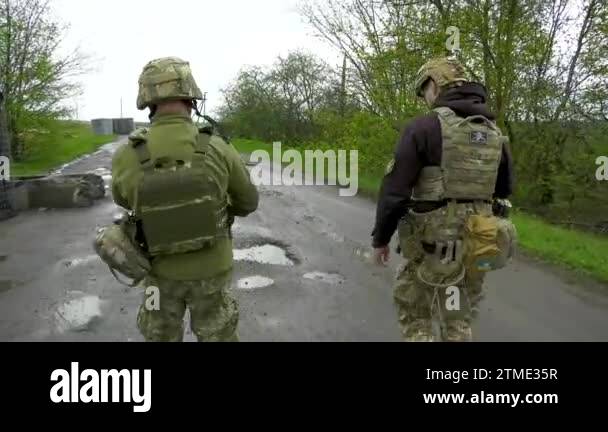 Two soldiers in military uniforms, bulletproof vests and helmets, with ...